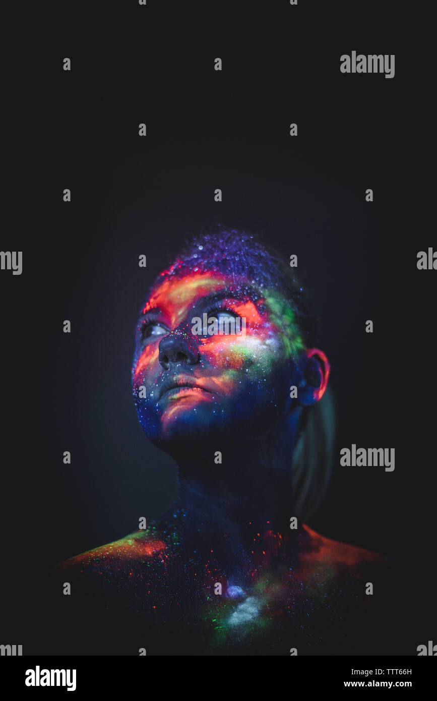 Conceptual shot of light and shine fluorescent colors young girl's face ...