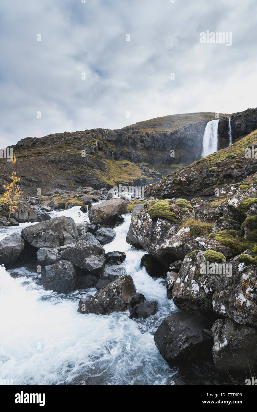 Scenic view of waterfall over rock formations Stock Photo - Alamy