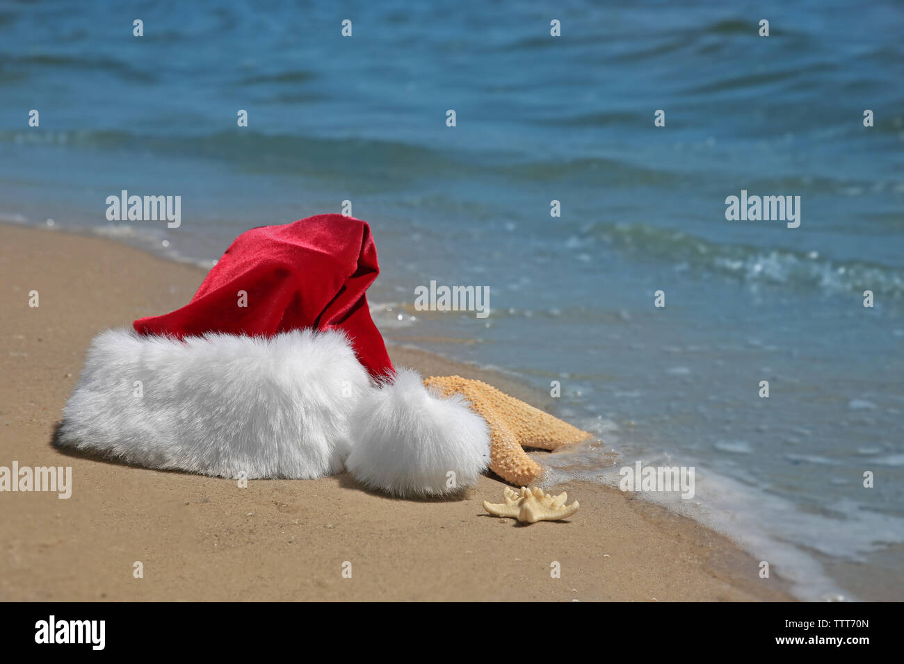 Santa hat with sea stars on beach Stock Photo - Alamy