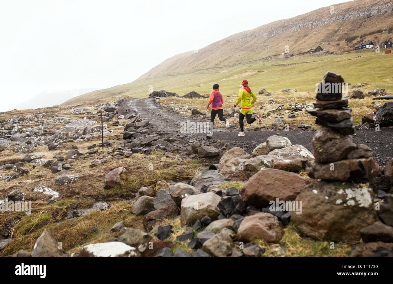 Female friends jogging on mountain path Stock Photo - Alamy