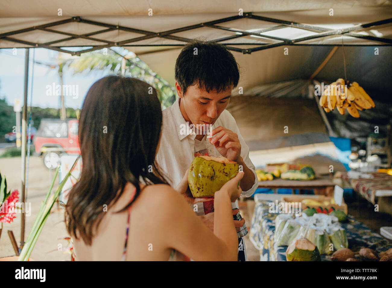 Couple drinking coconut water at market stall Stock Photo - Alamy