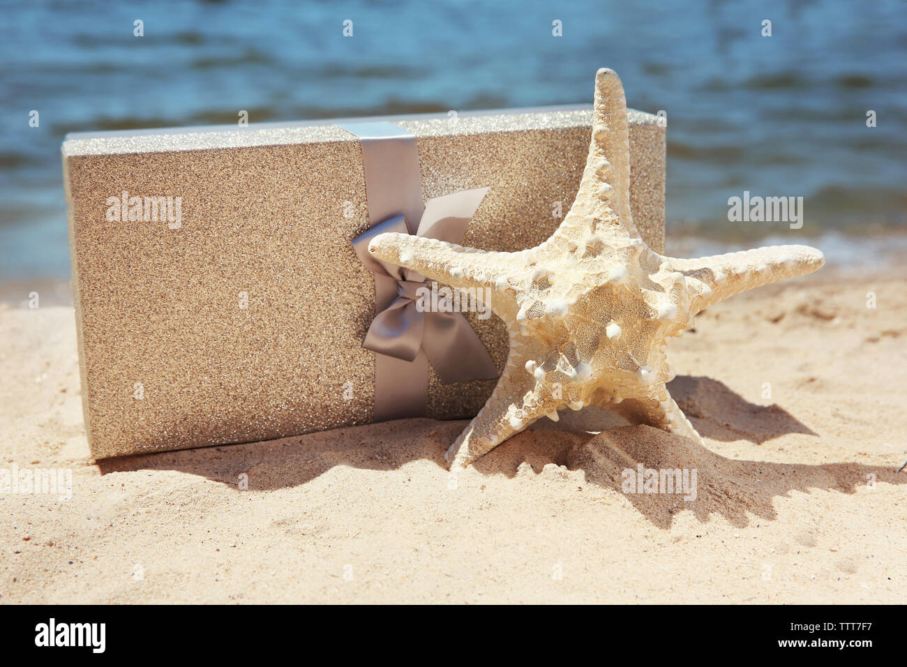 Gift box with sea star on beach. Christmas holiday concept Stock Photo ...