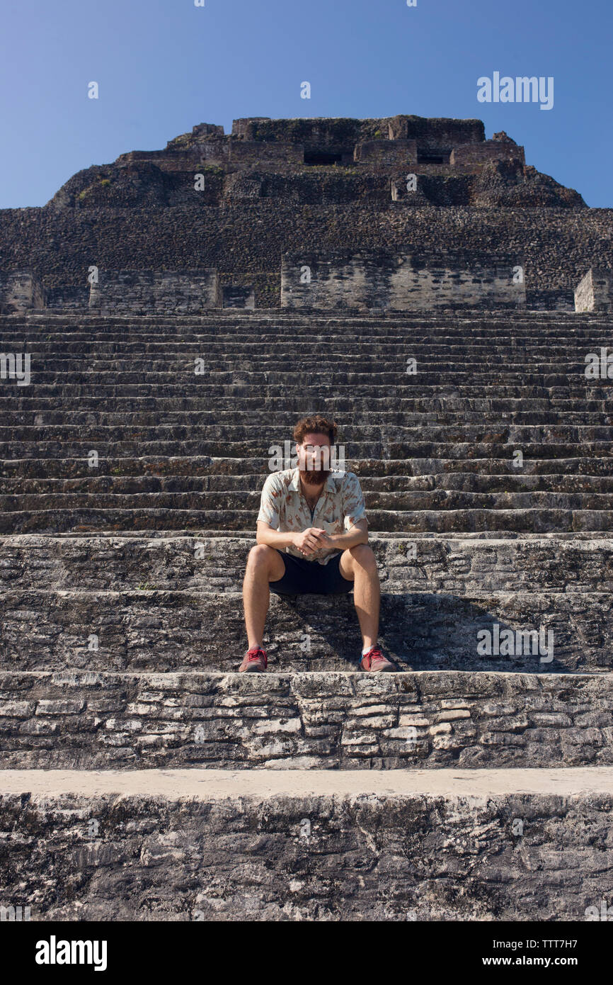 Man sitting outside ruins Stock Photo - Alamy