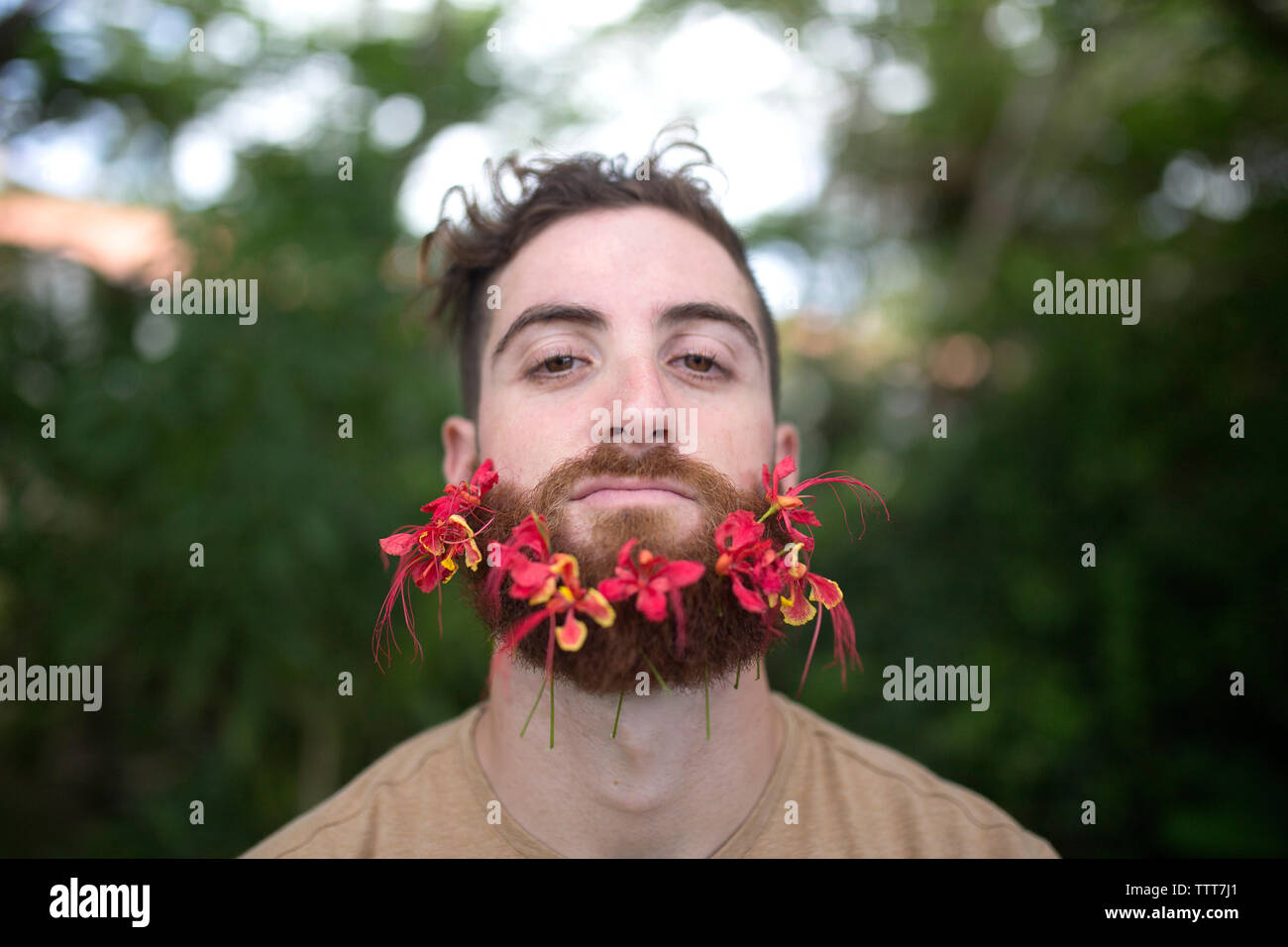Man with tropical flowers in beard Stock Photo - Alamy