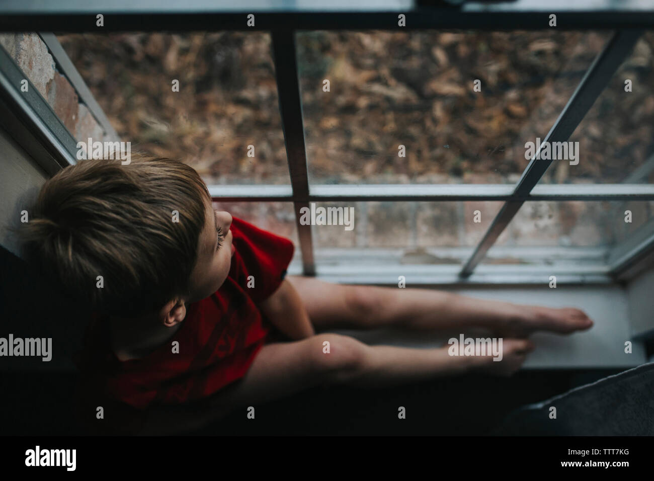 Boy window sill hi-res stock photography and images - Alamy