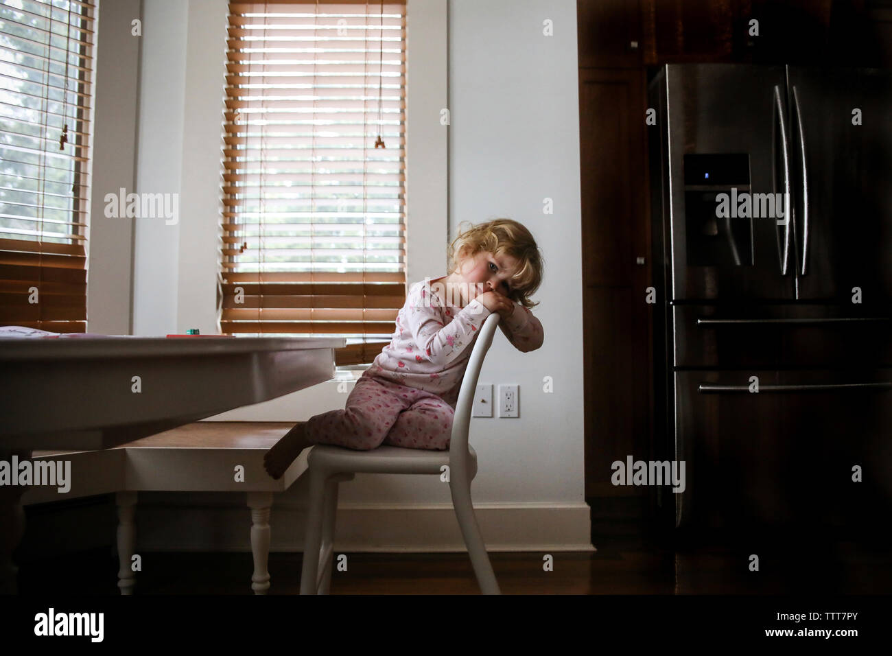 Portrait of bored girl sitting on chair at home Stock Photo - Alamy