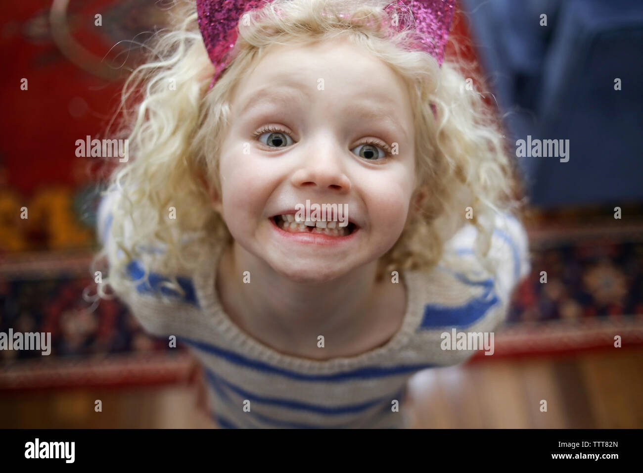 High angle portrait of cute girl showing gap toothed at home Stock ...
