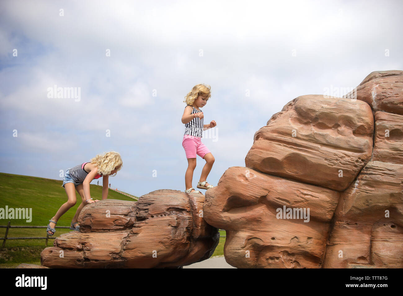 little girls climbing rocks in striped shirt blue skies Stock Photo - Alamy