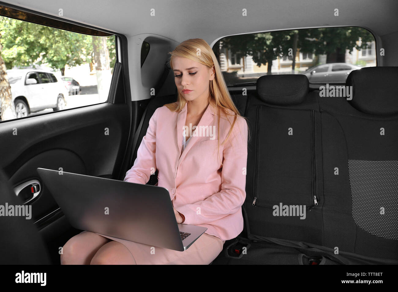 Businesswoman with laptop in a car Stock Photo - Alamy