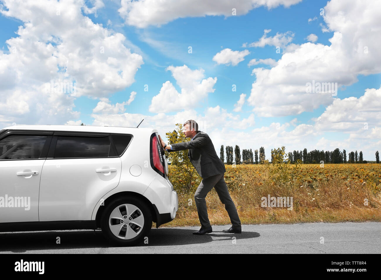 Man pushing damaged car Stock Photo - Alamy