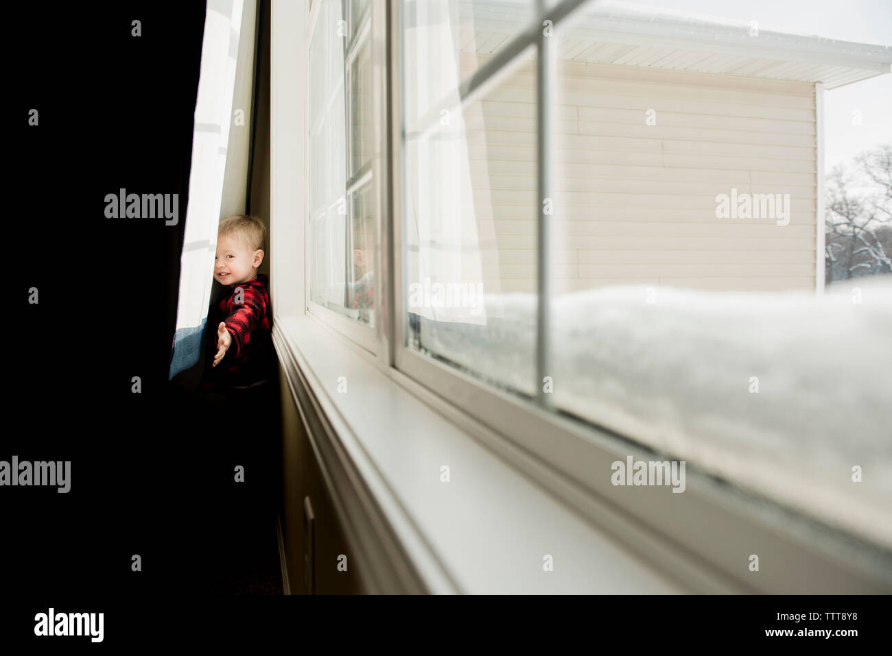 Portrait of playful boy standing behind curtains at home Stock Photo ...