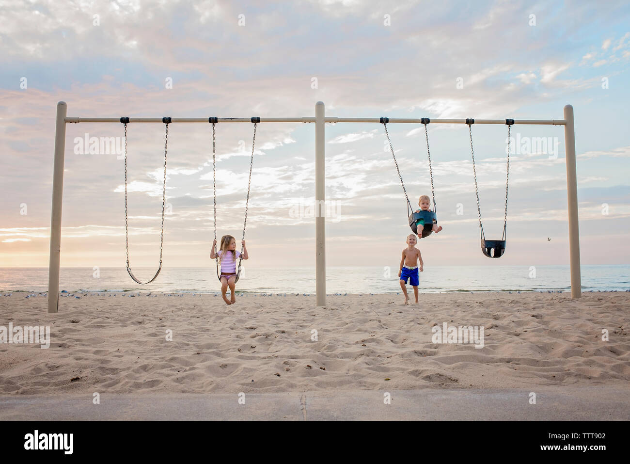 Boy girl on swings hi-res stock photography and images - Alamy