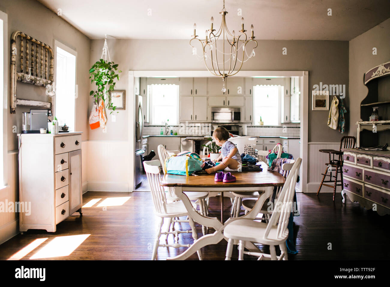 Baby boy sitting on dining table in living room Stock Photo - Alamy