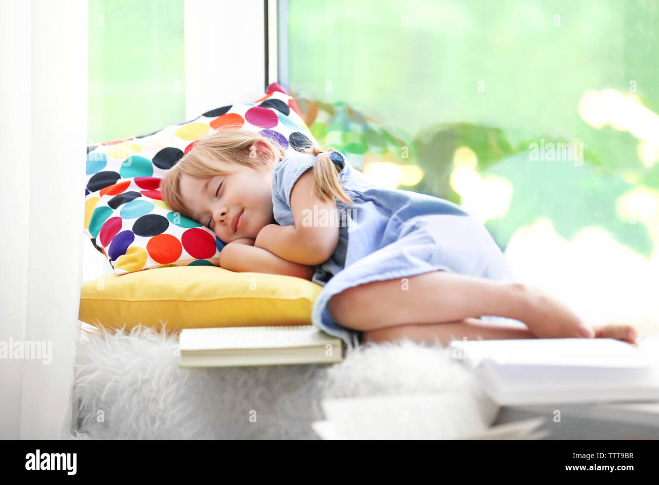 Cute little girl sleeping on windowsill Stock Photo - Alamy