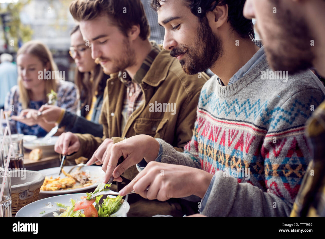 Male and female friends having lunch at outdoor restaurant Stock Photo ...