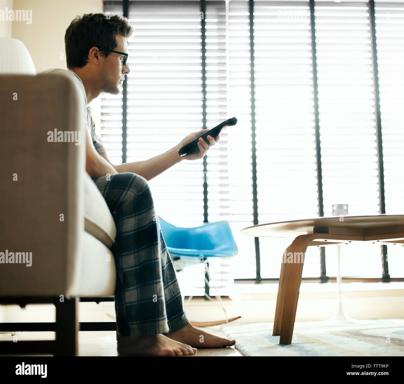 Side view of man watching television at home Stock Photo - Alamy