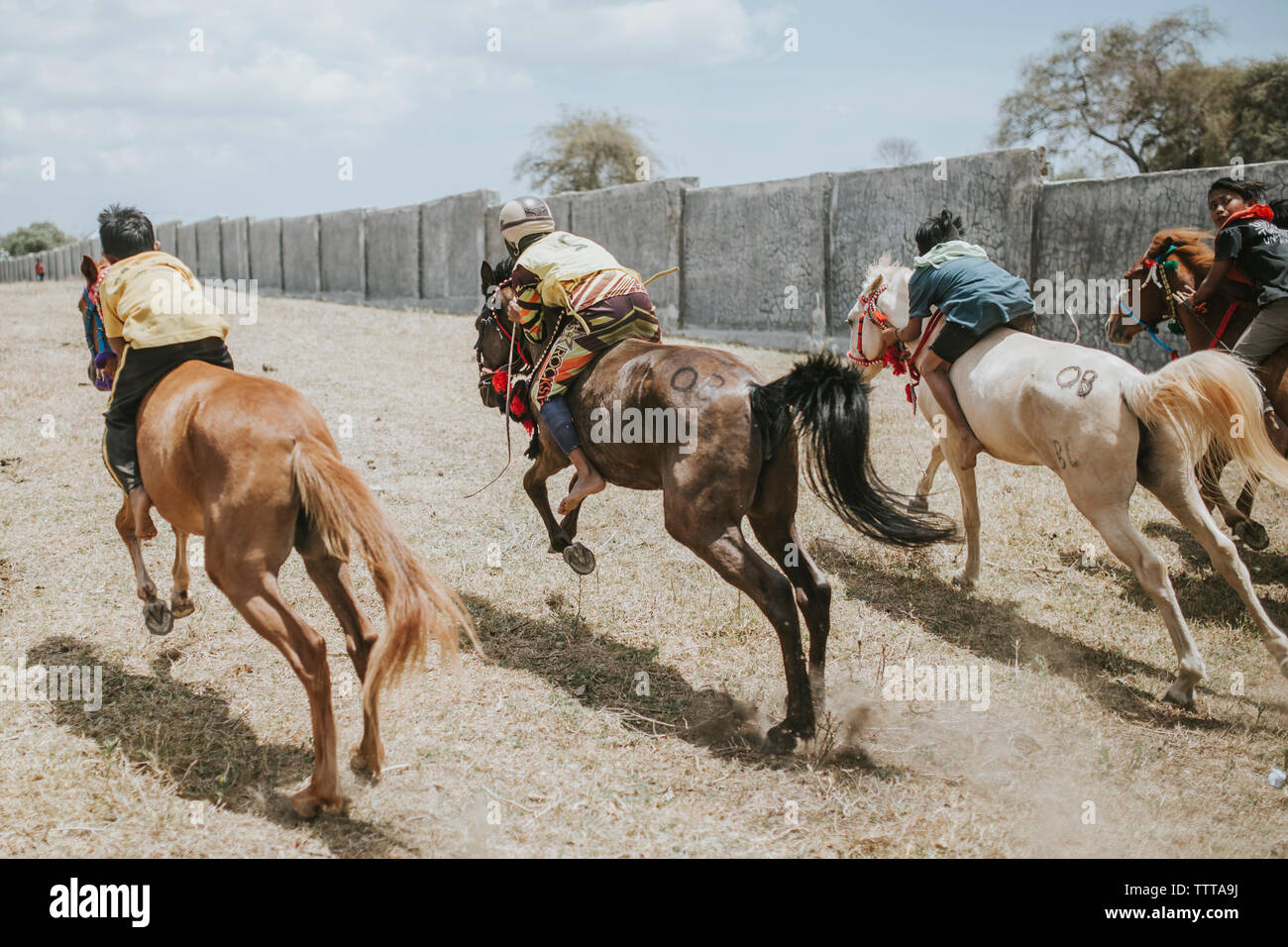 Rear view of jockeys riding racehorses during horse racing Stock Photo ...