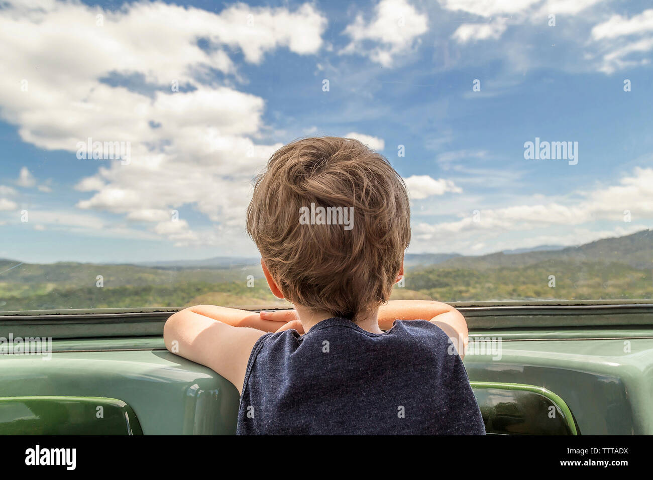 Boy looking through rear windshield while traveling in car Stock Photo ...