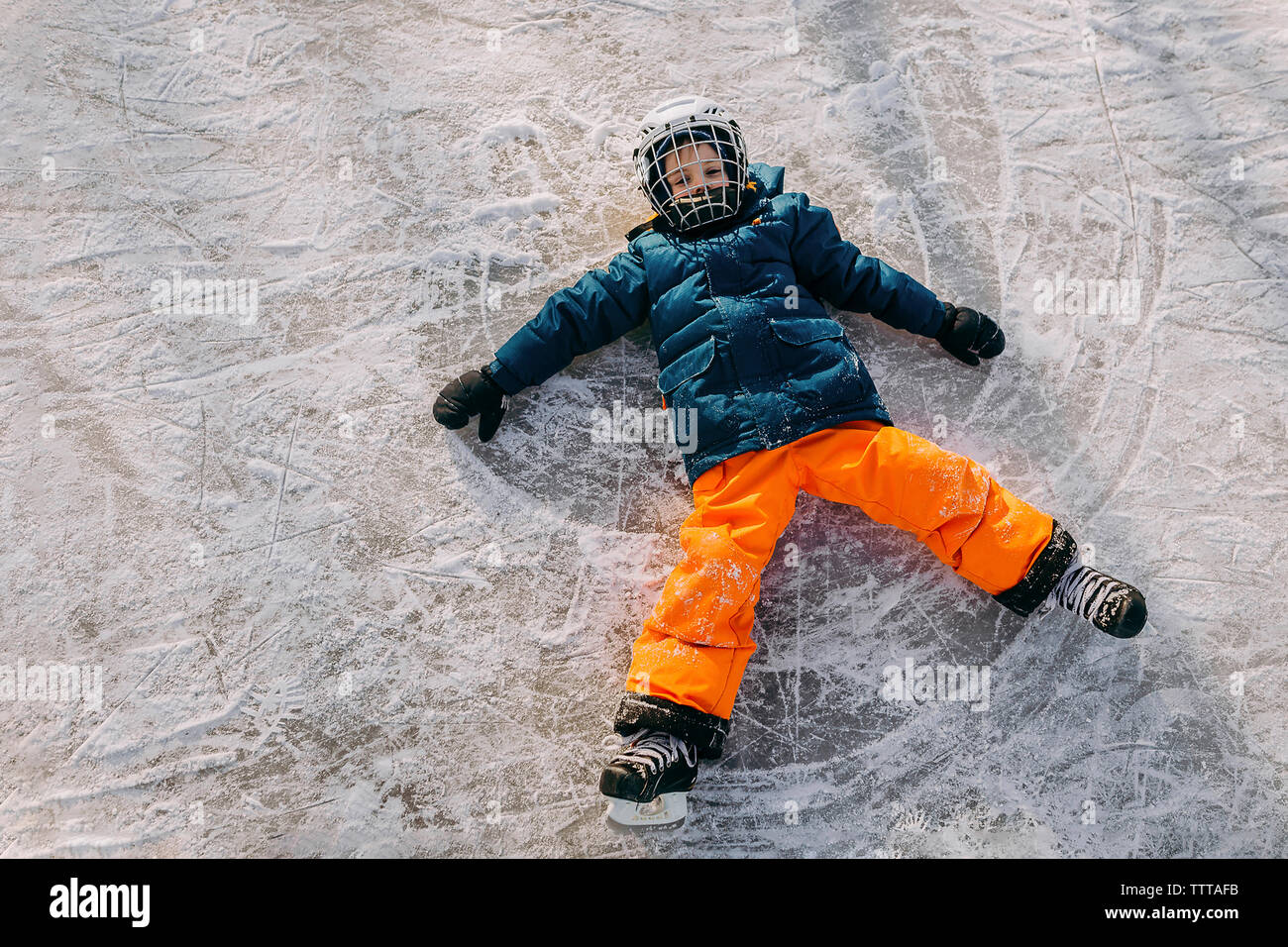High angle portrait of boy making snow angel Stock Photo - Alamy
