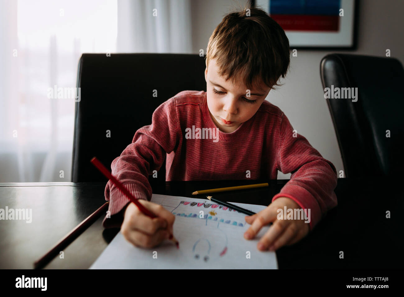 Boy drawing with colored pencil on paper at home Stock Photo - Alamy