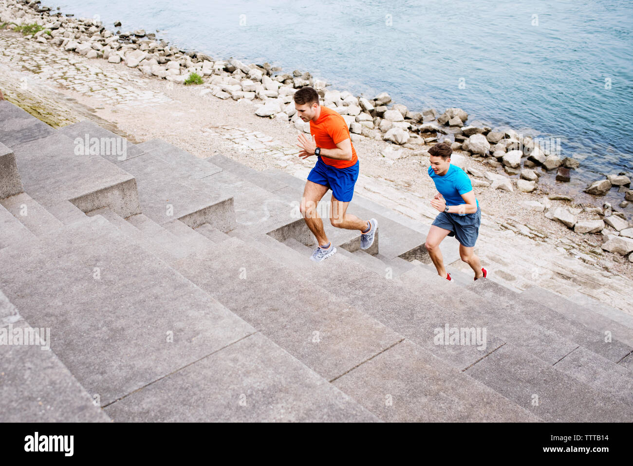 High angle view of male athletes running on steps at beach Stock Photo ...