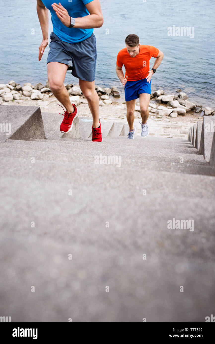 High angle view of male athletes running on steps at beach Stock Photo ...