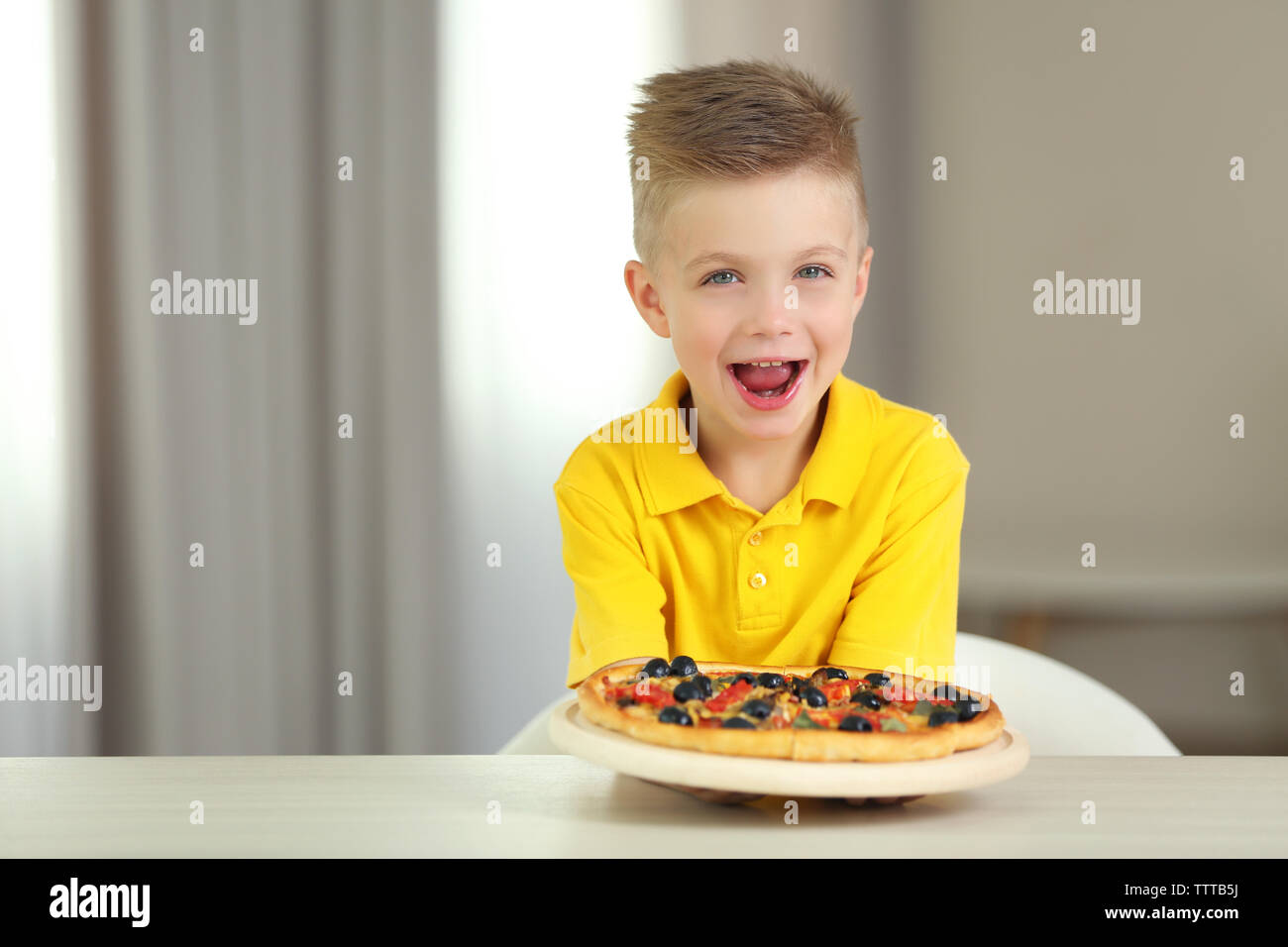 Cute boy with hot pizza at home Stock Photo - Alamy