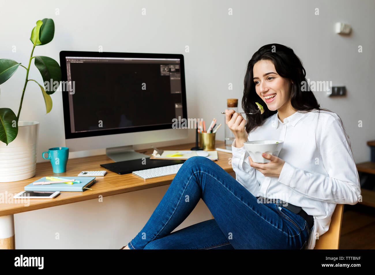 Person eating at work desk hi-res stock photography and images - Alamy