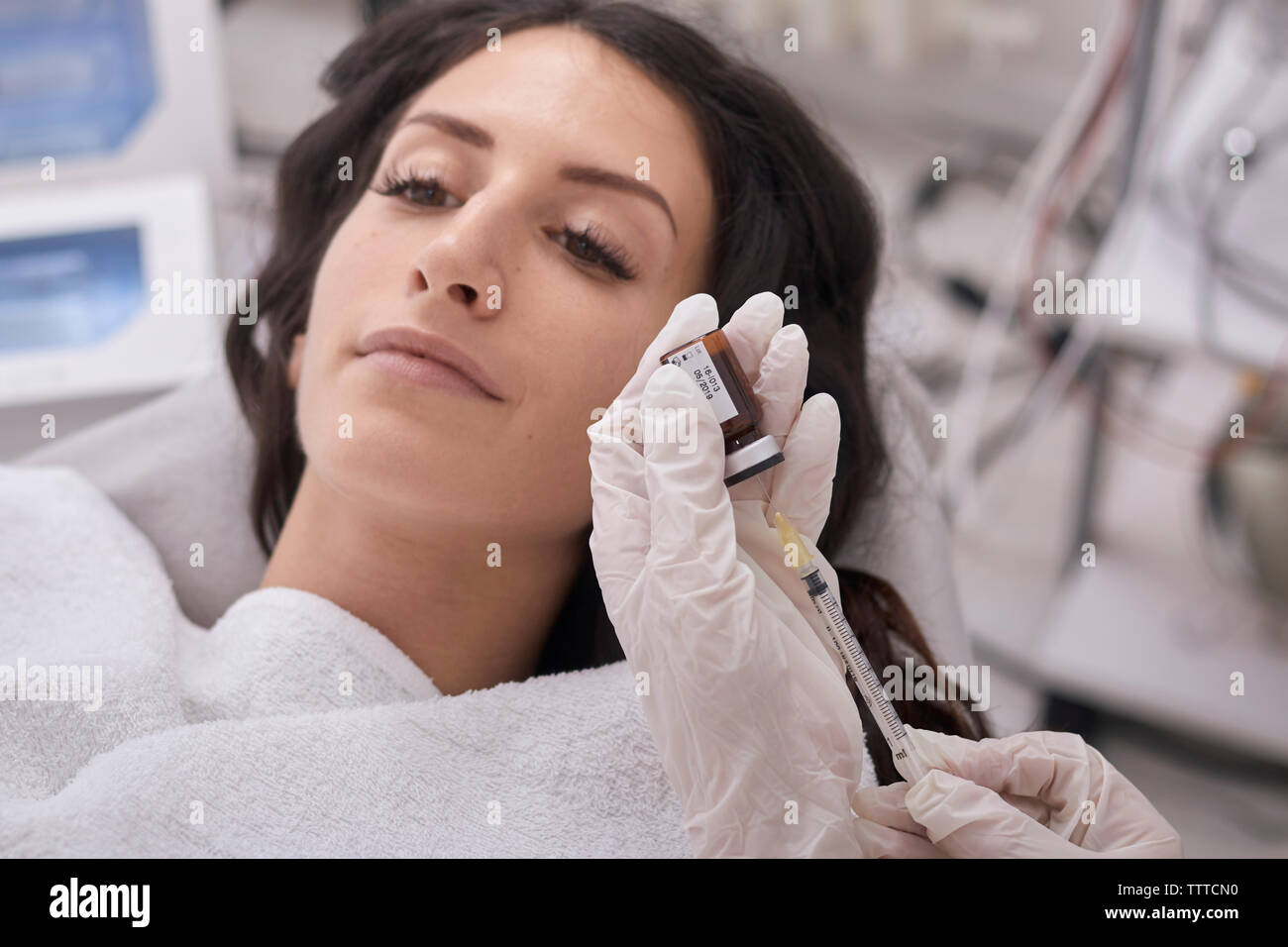 Cropped hands of female doctor filling botox injection while patient ...