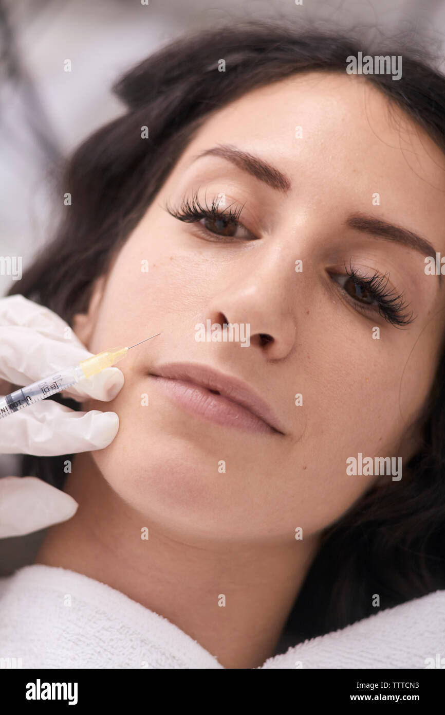 Cropped hands of female doctor injecting botox injection on patient's ...