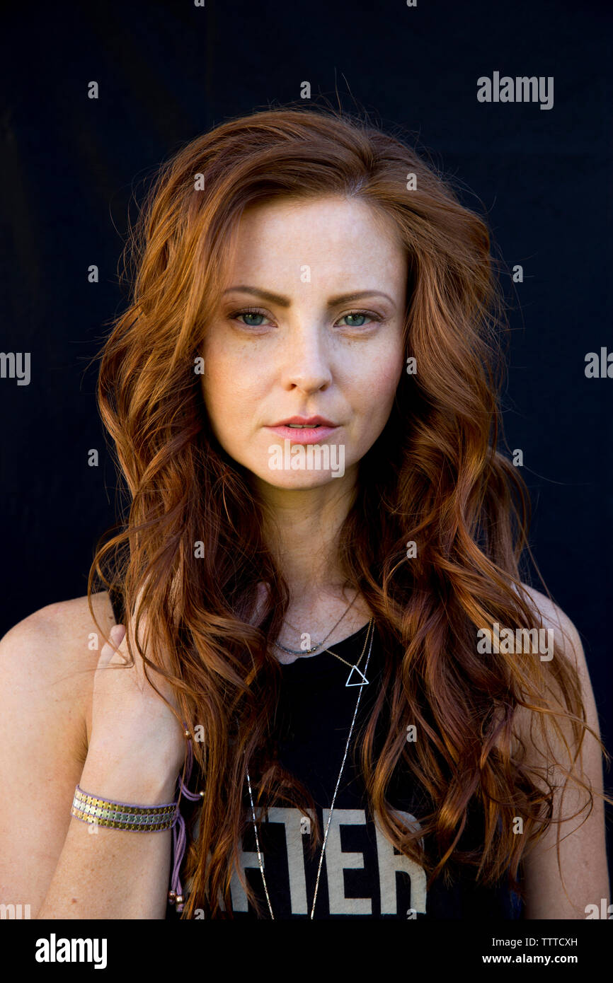 Portrait of woman standing against wall Stock Photo - Alamy