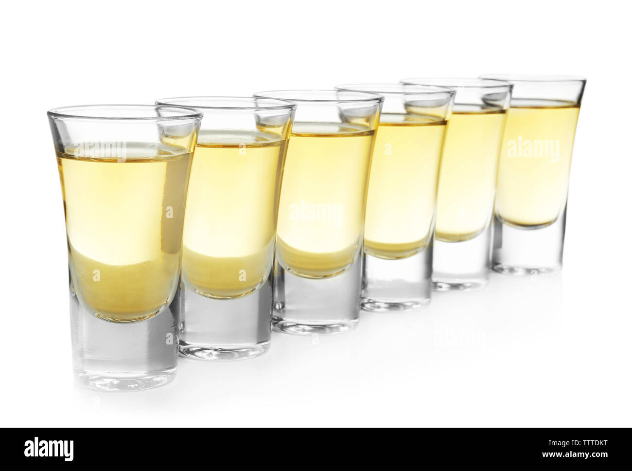 Shots of gold tequila in row isolated on white Stock Photo - Alamy