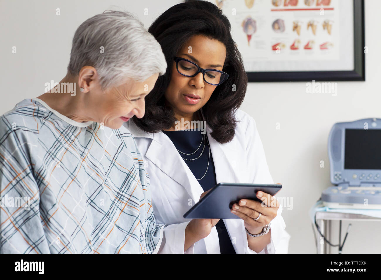 Female doctor explaining report to patient in clinic Stock Photo - Alamy