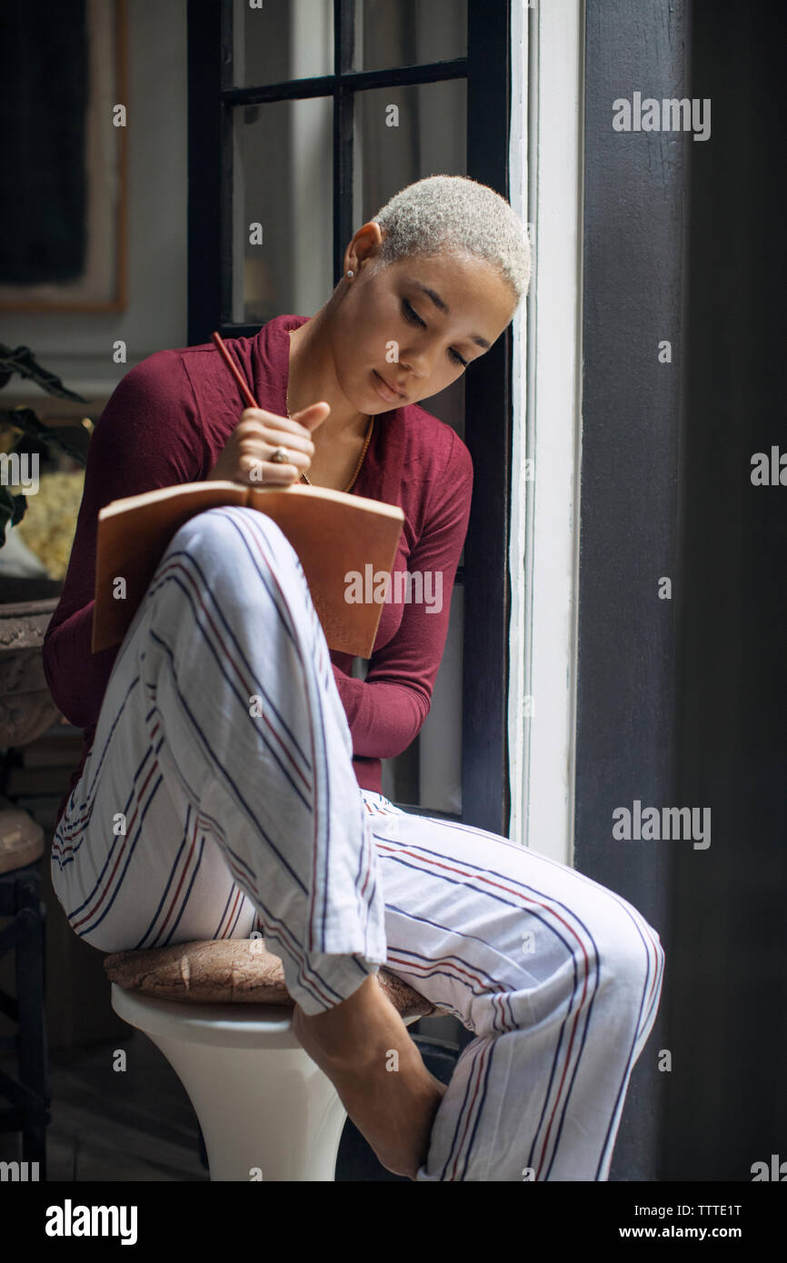 Woman sitting on stool hi-res stock photography and images - Alamy