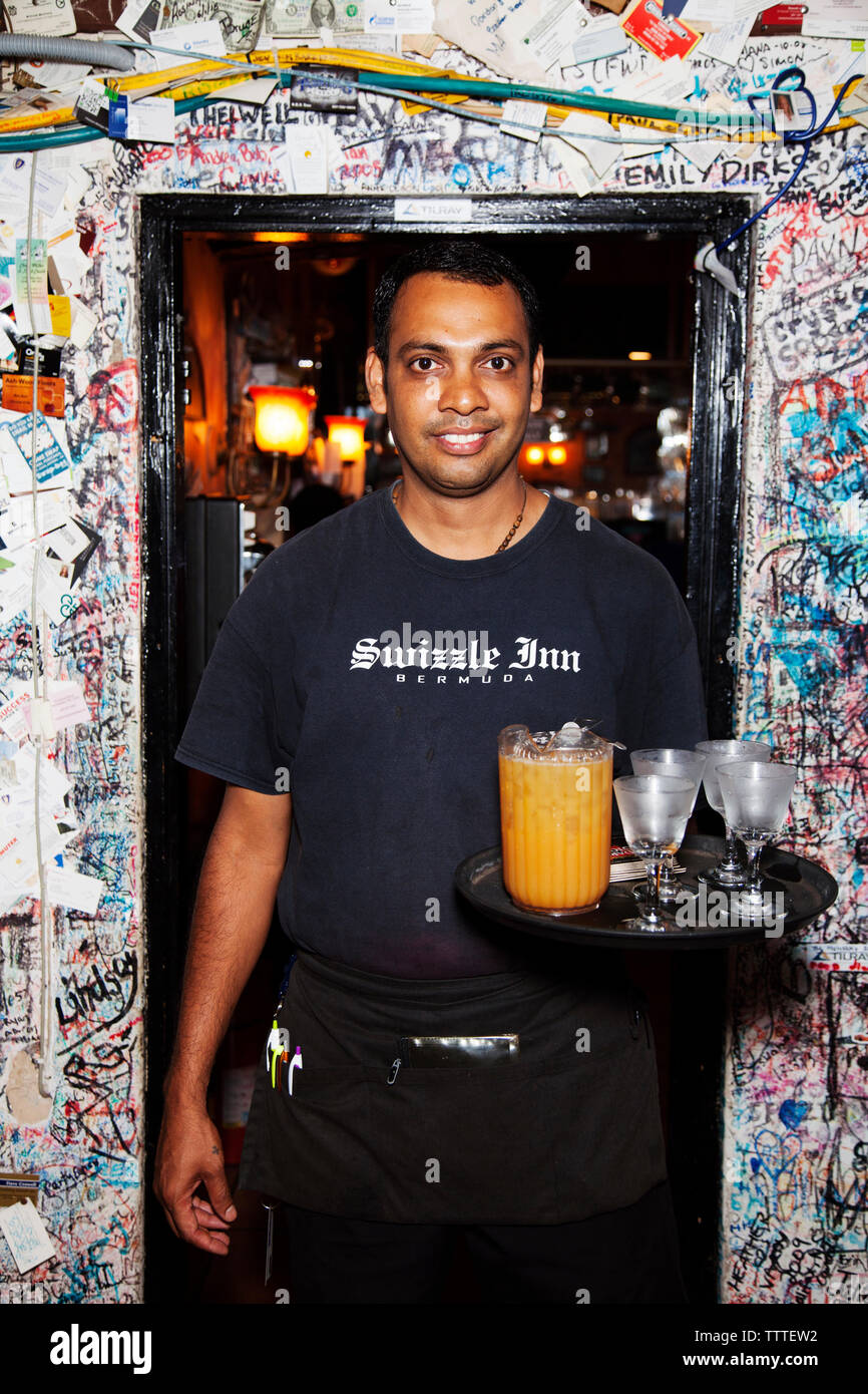 BERMUDA. Harry, a waiter, holding a pitcher of the famous Rum Swizzle ...