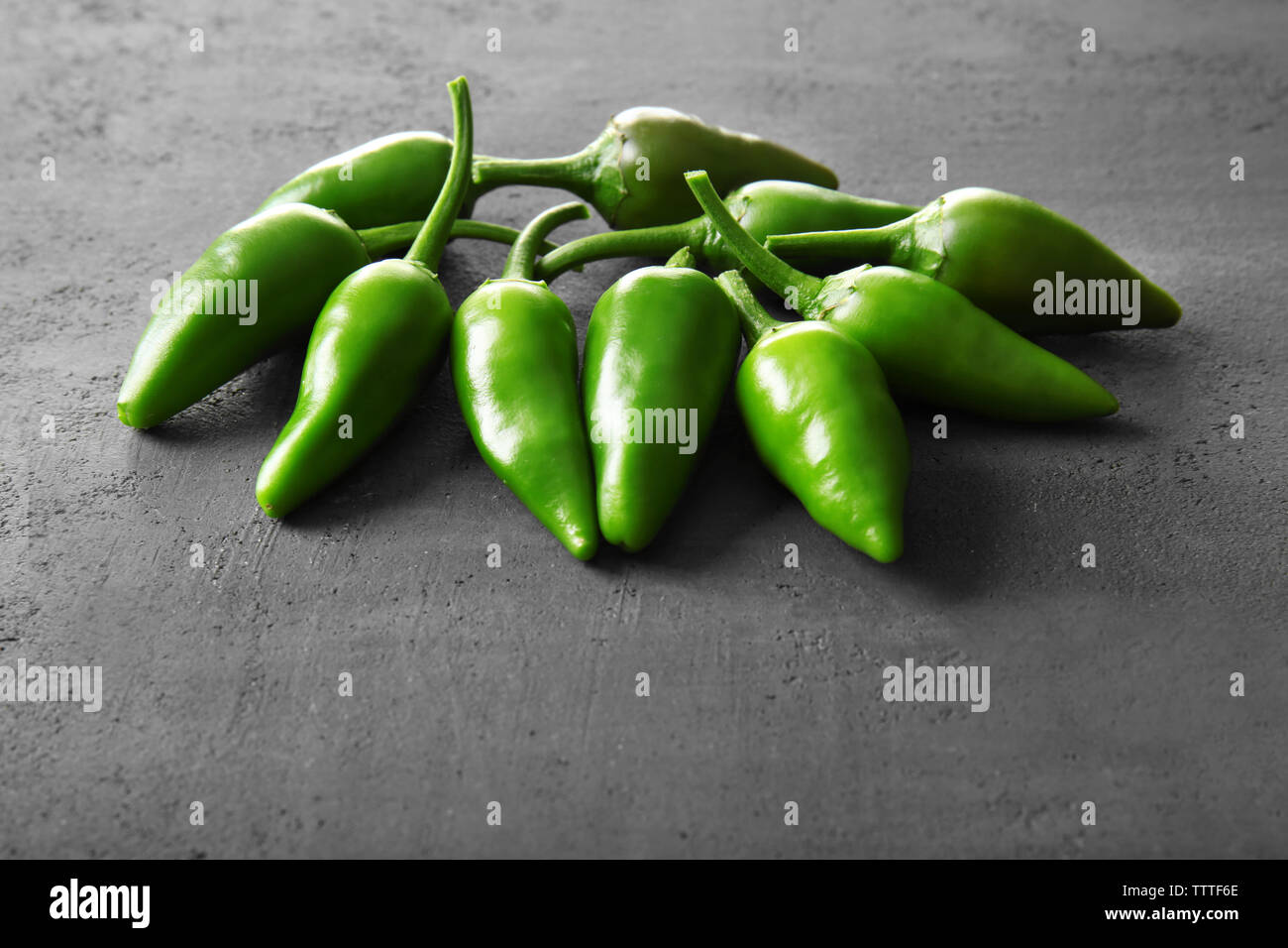 Green peppers on grey table Stock Photo - Alamy