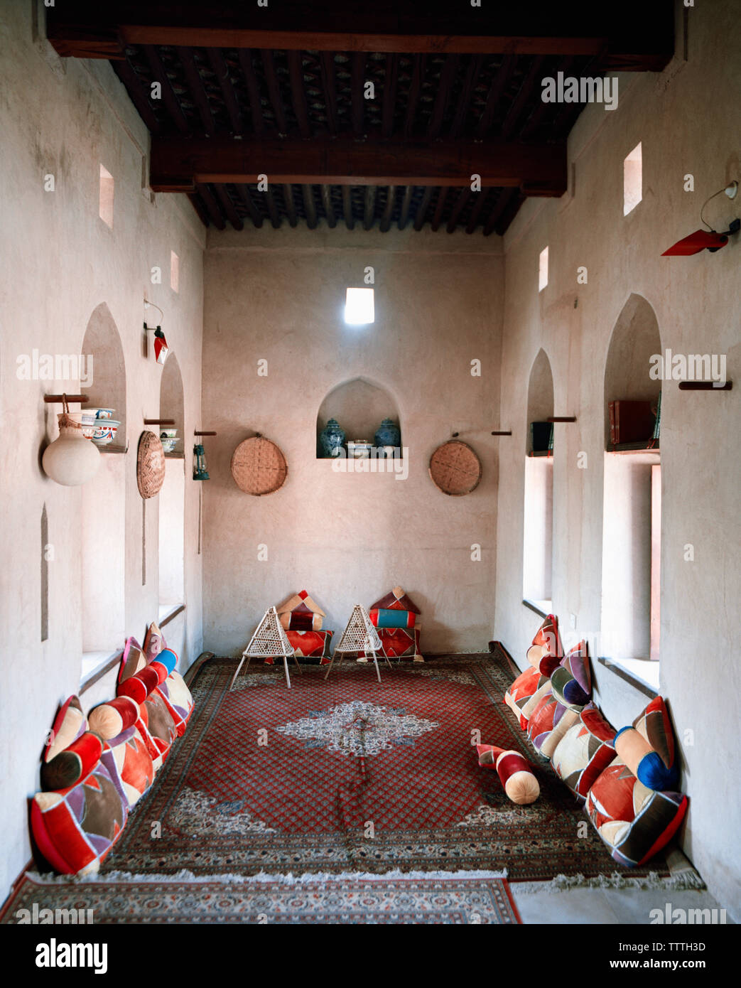 OMAN, Middle East, Muscat, pillows arranged on carpet in empty room ...