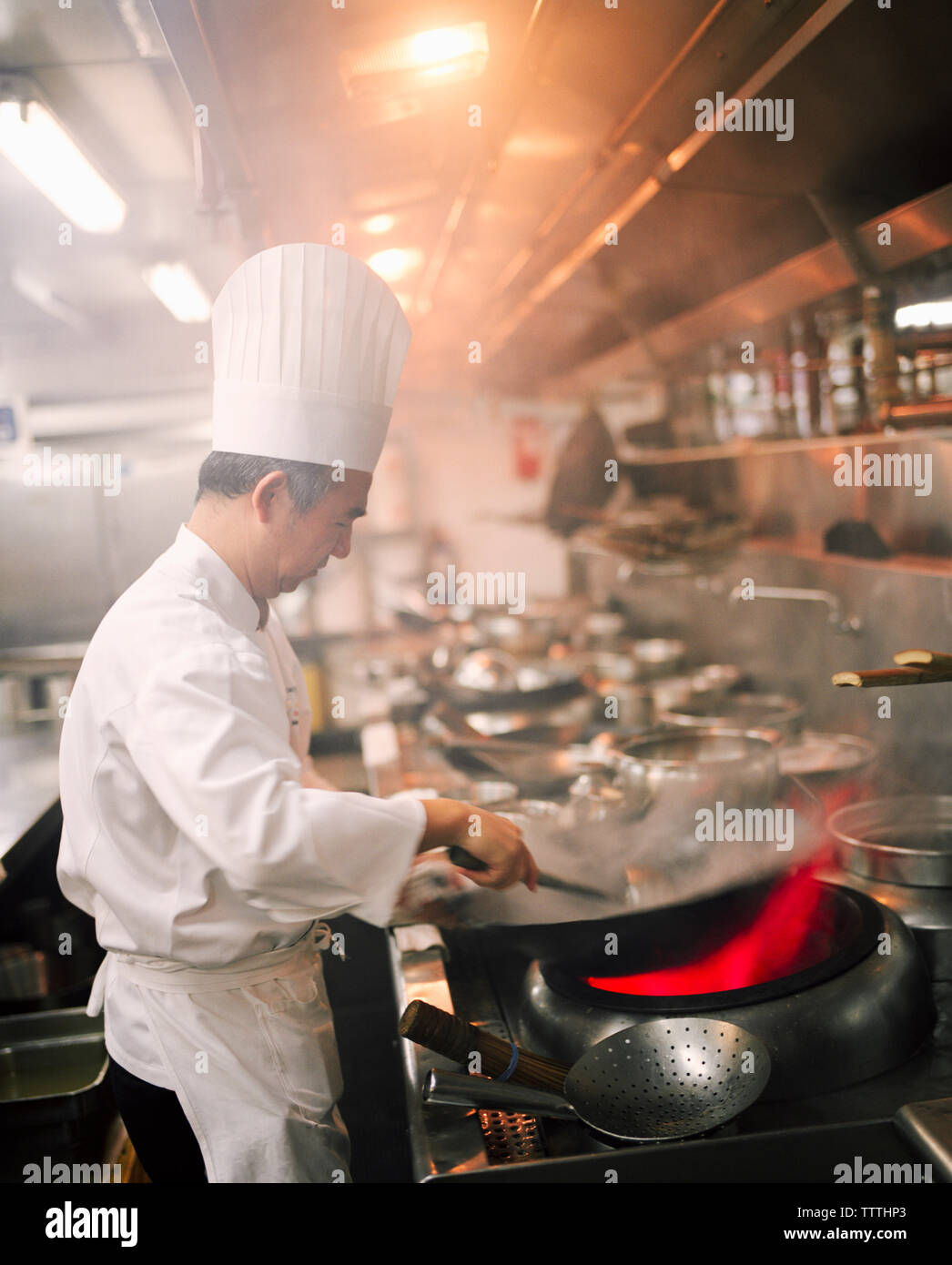 SINGAPORE, Asia, side view of a chef preparing food at Orchard Hotel ...