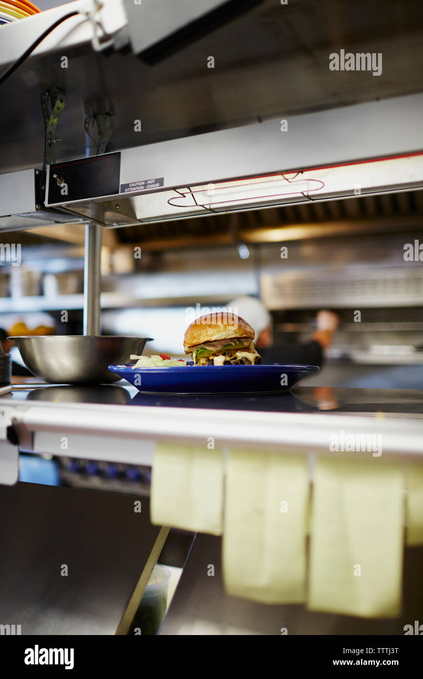 Cheeseburger in plate on commercial kitchen counter Stock Photo - Alamy