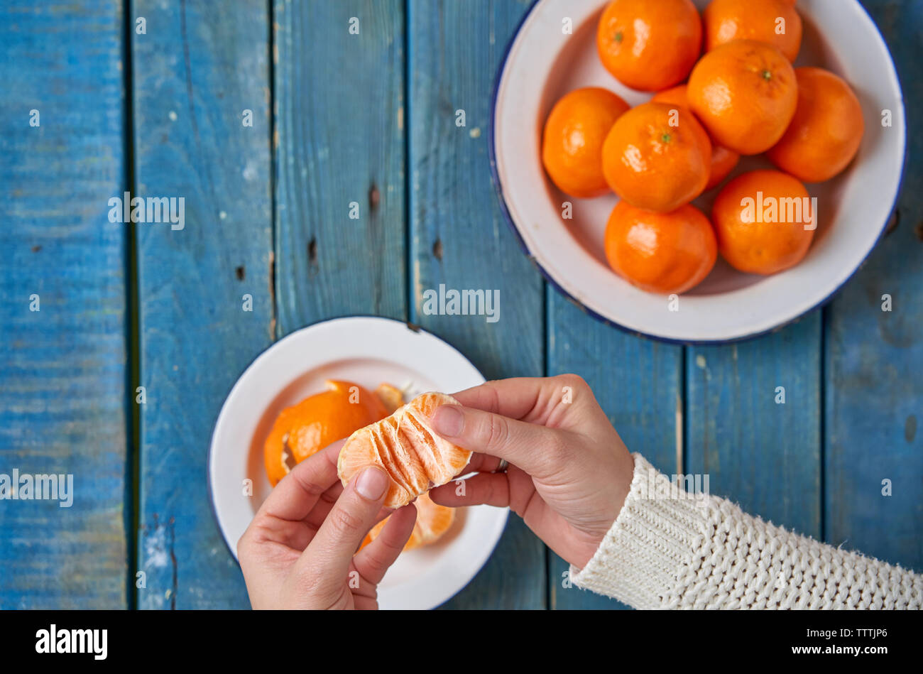Hand holding some tangerines over blue table Stock Photo - Alamy