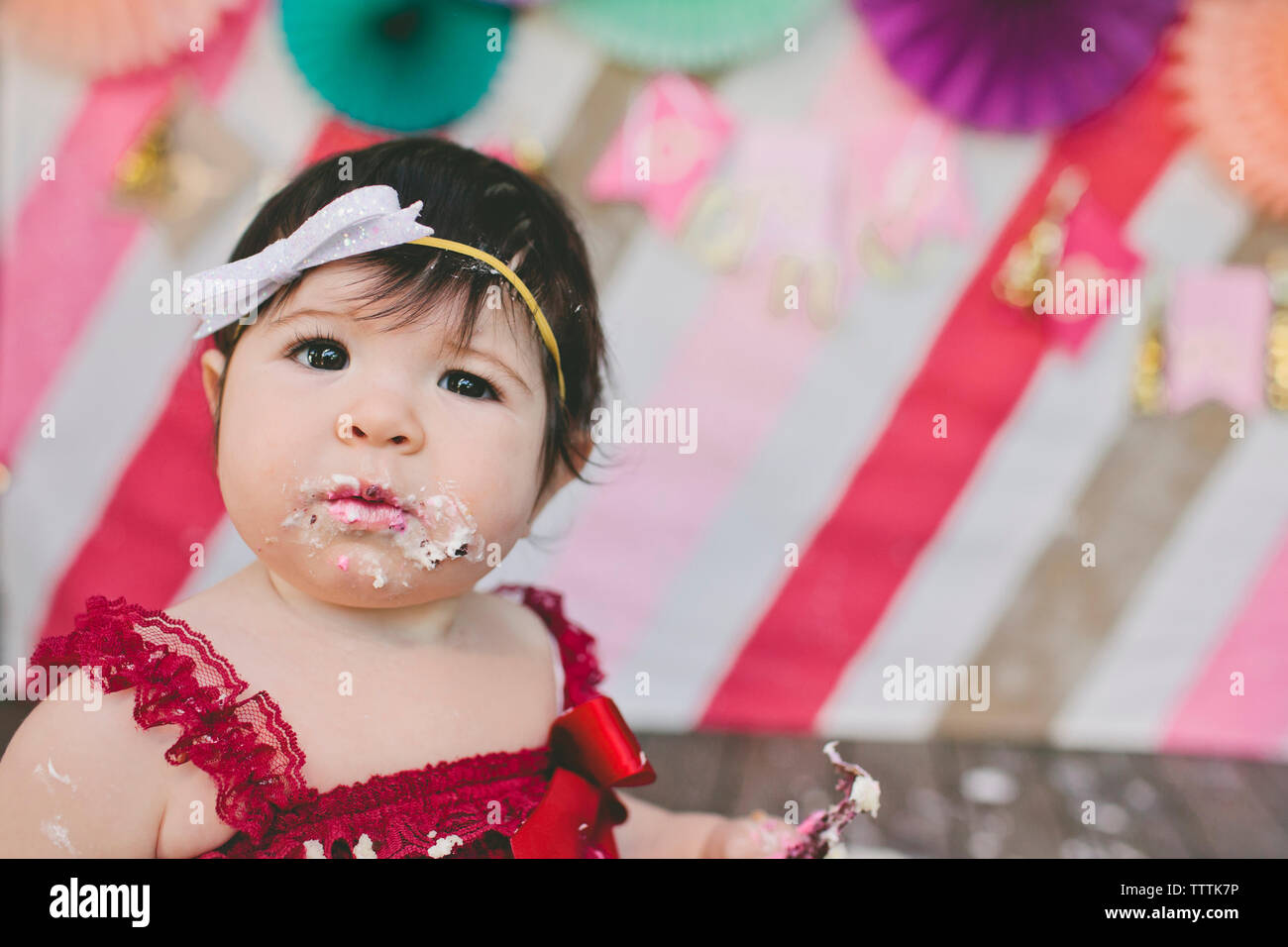 Portrait of cute baby girl with messy face during birthday party Stock ...