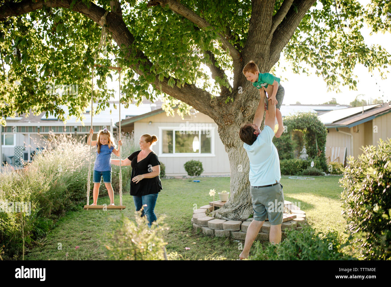 Happy family playing at front yard Stock Photo - Alamy