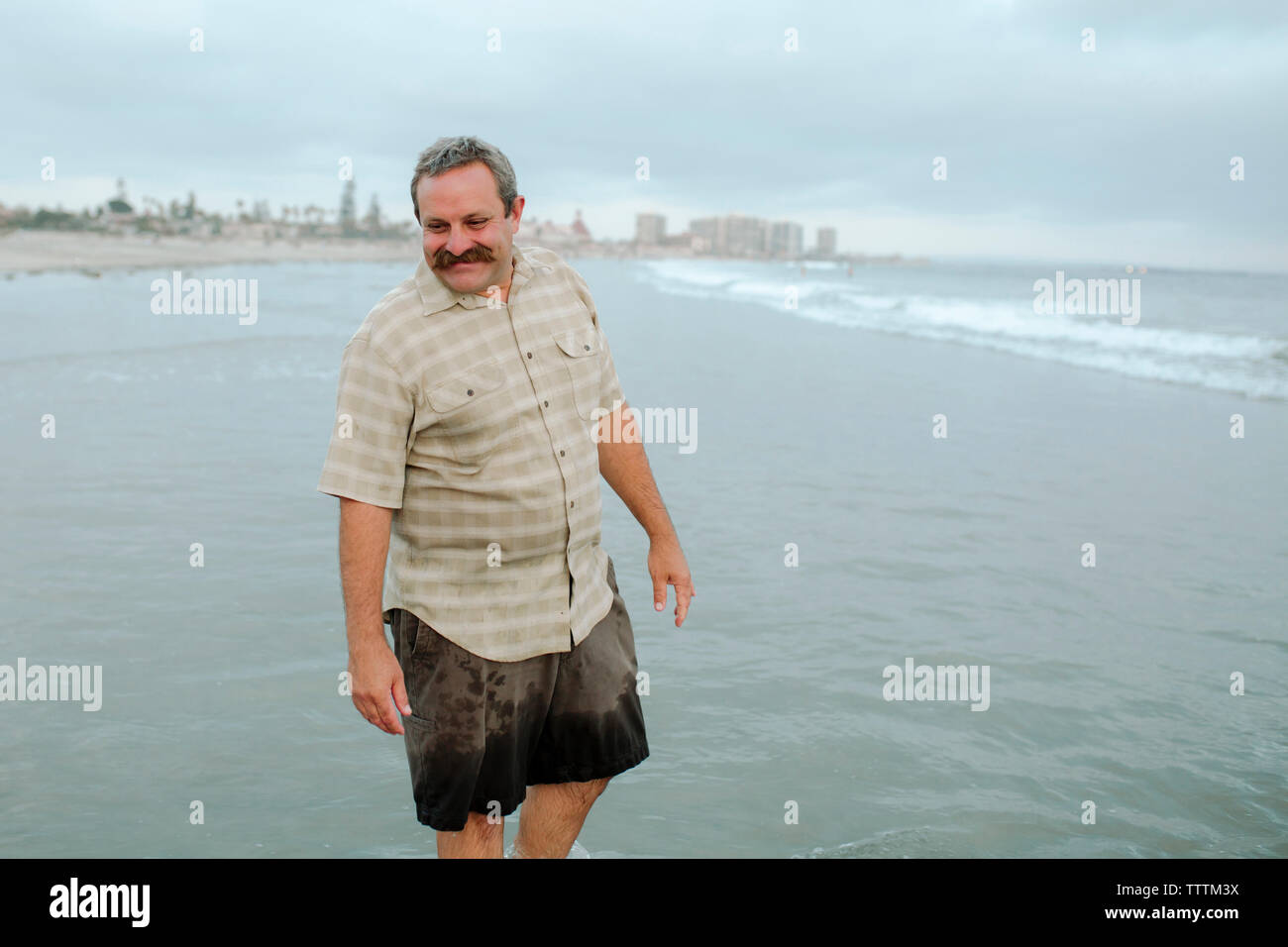 Man standing in sea at beach Stock Photo - Alamy