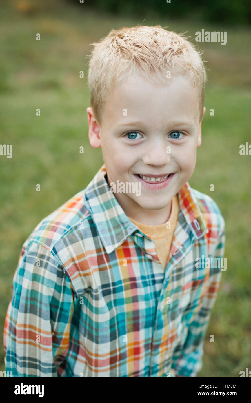 High angle portrait of happy boy standing on grassy field Stock Photo ...