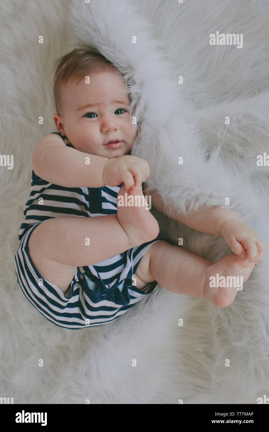 Overhead portrait of cute baby boy lying on rug Stock Photo - Alamy