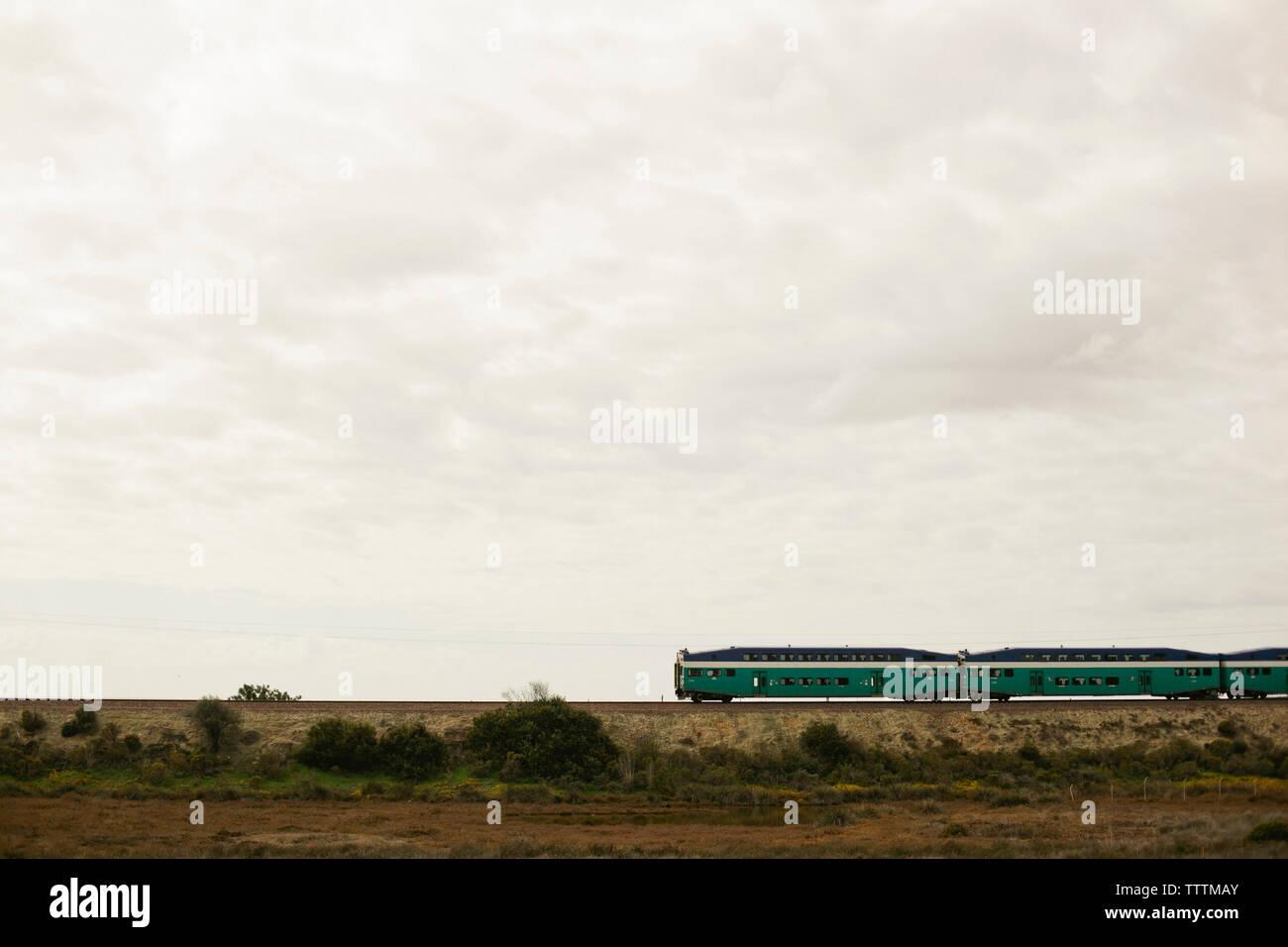 Train on railroad track against cloudy sky Stock Photo - Alamy