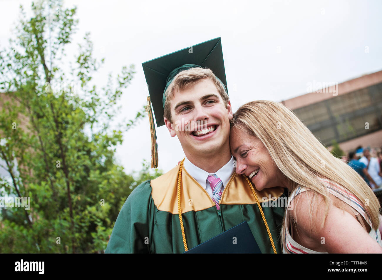 Happy mother leaning head on sons shoulder at graduation ceremony Stock ...