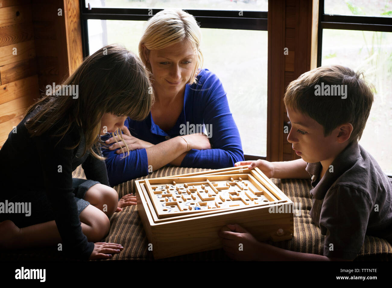 Family playing maze game in house Stock Photo - Alamy