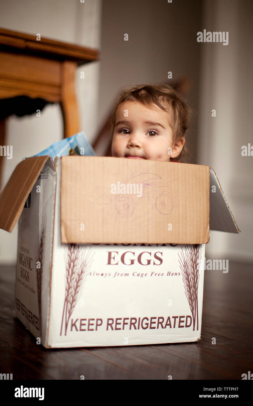 Portrait of baby girl sitting in sitting in box Stock Photo - Alamy