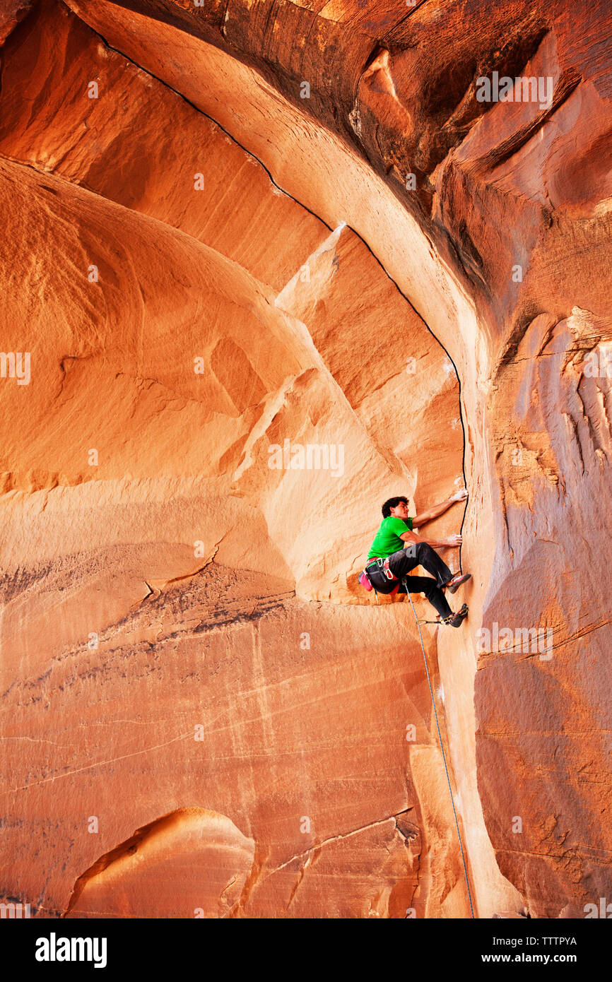 Side view of man climbing mountain Stock Photo - Alamy